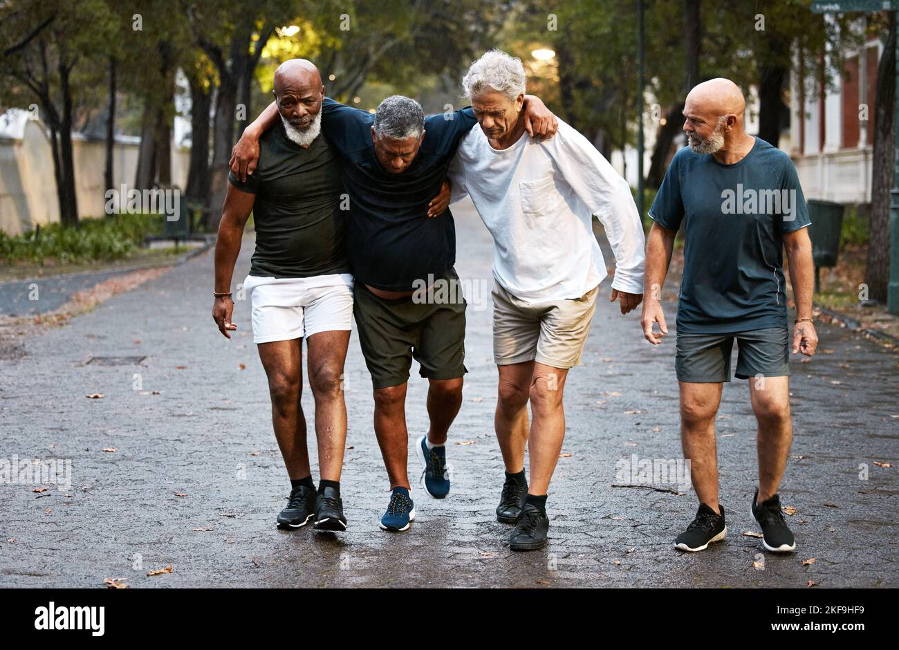 Help, injury and fitness with man friends in a park together for ...