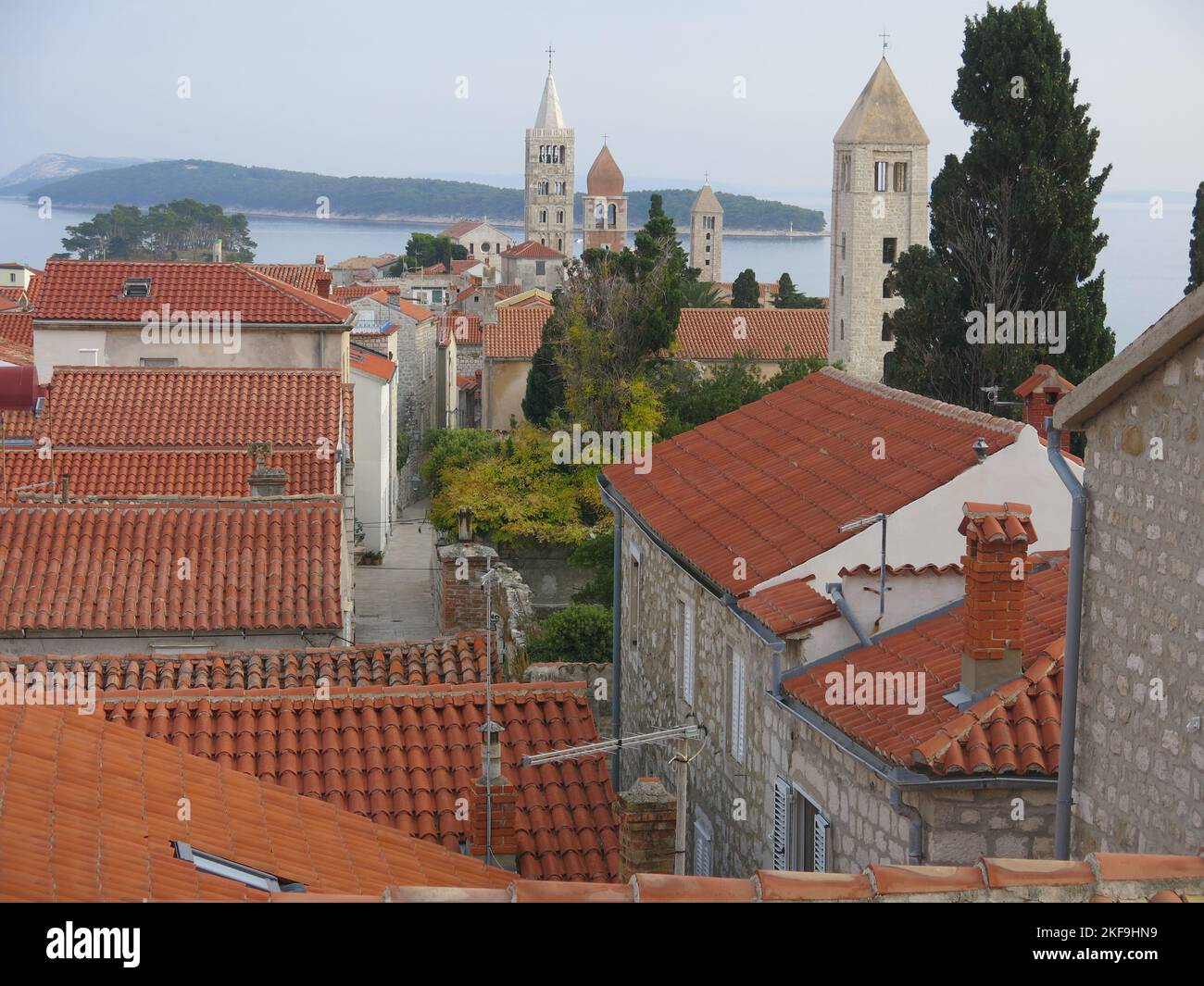 A view of red tiled rooftops and the four tall bell towers of the ...