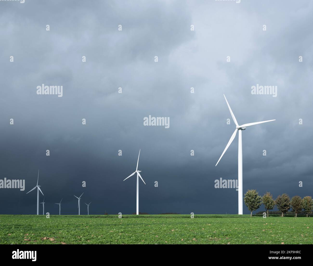dark threatening grey sky and white wind turbines in belgium Stock ...