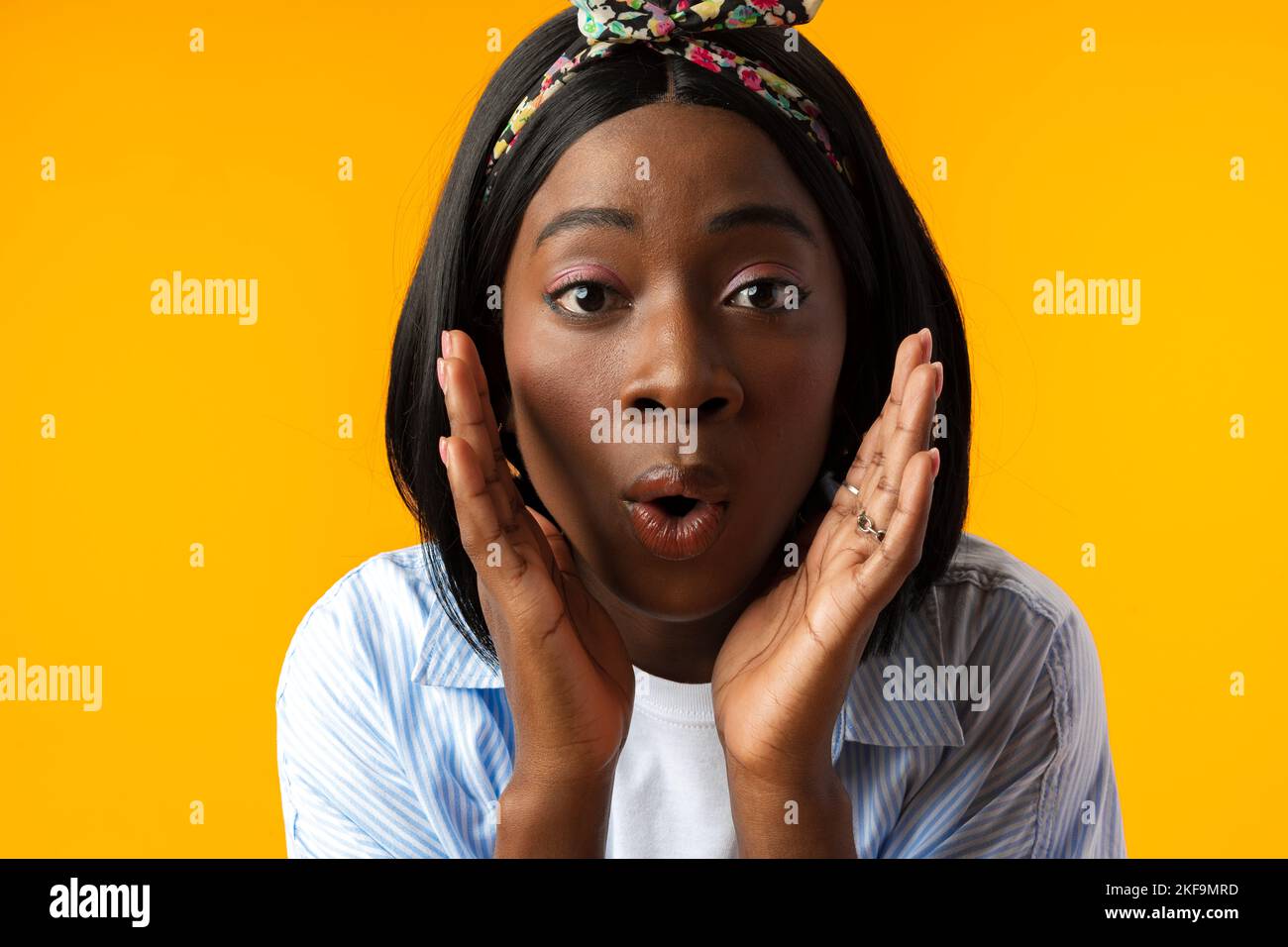 Surprised happy young african woman express shock against yellow ...