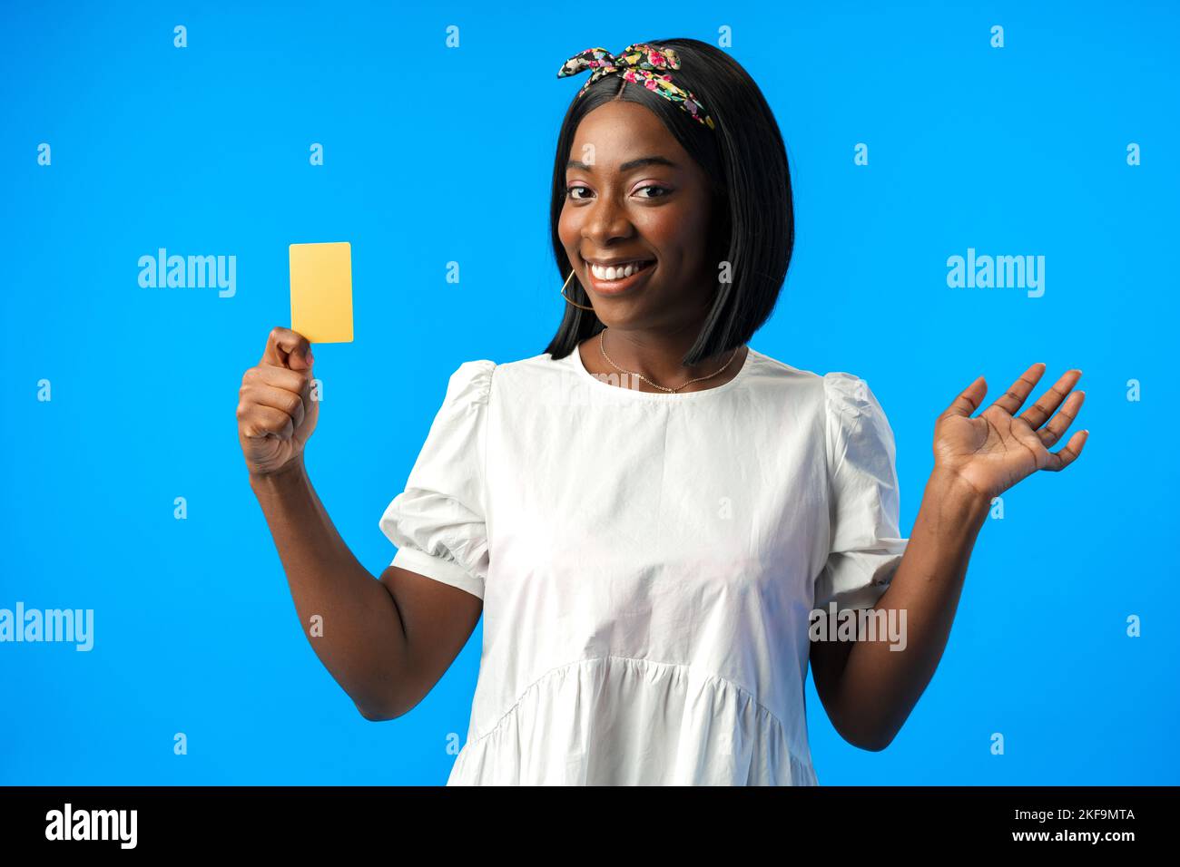 Young african woman holding credit card in hand against blue background ...