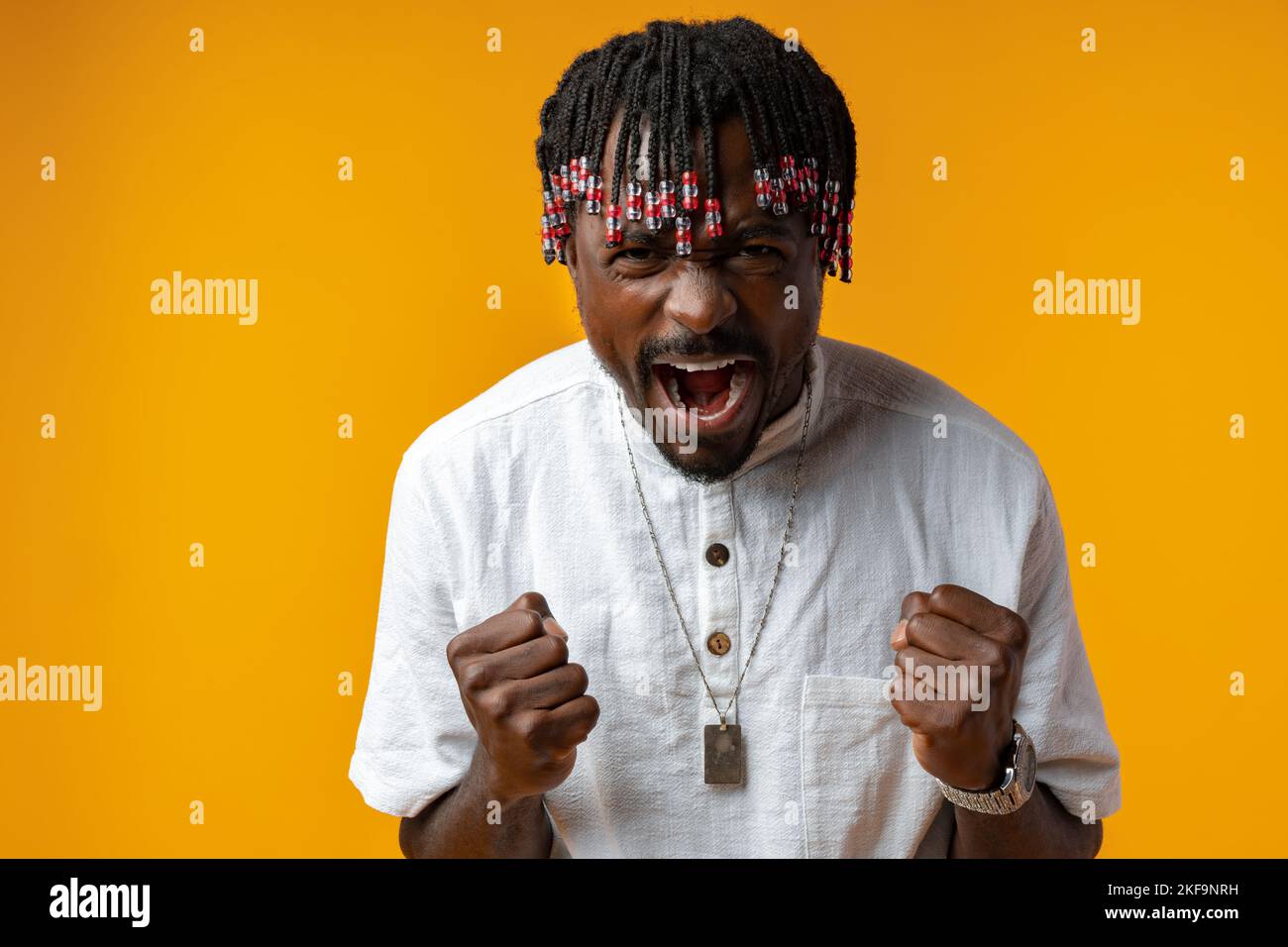 Emotional screaming young african man on yellow background Stock Photo ...
