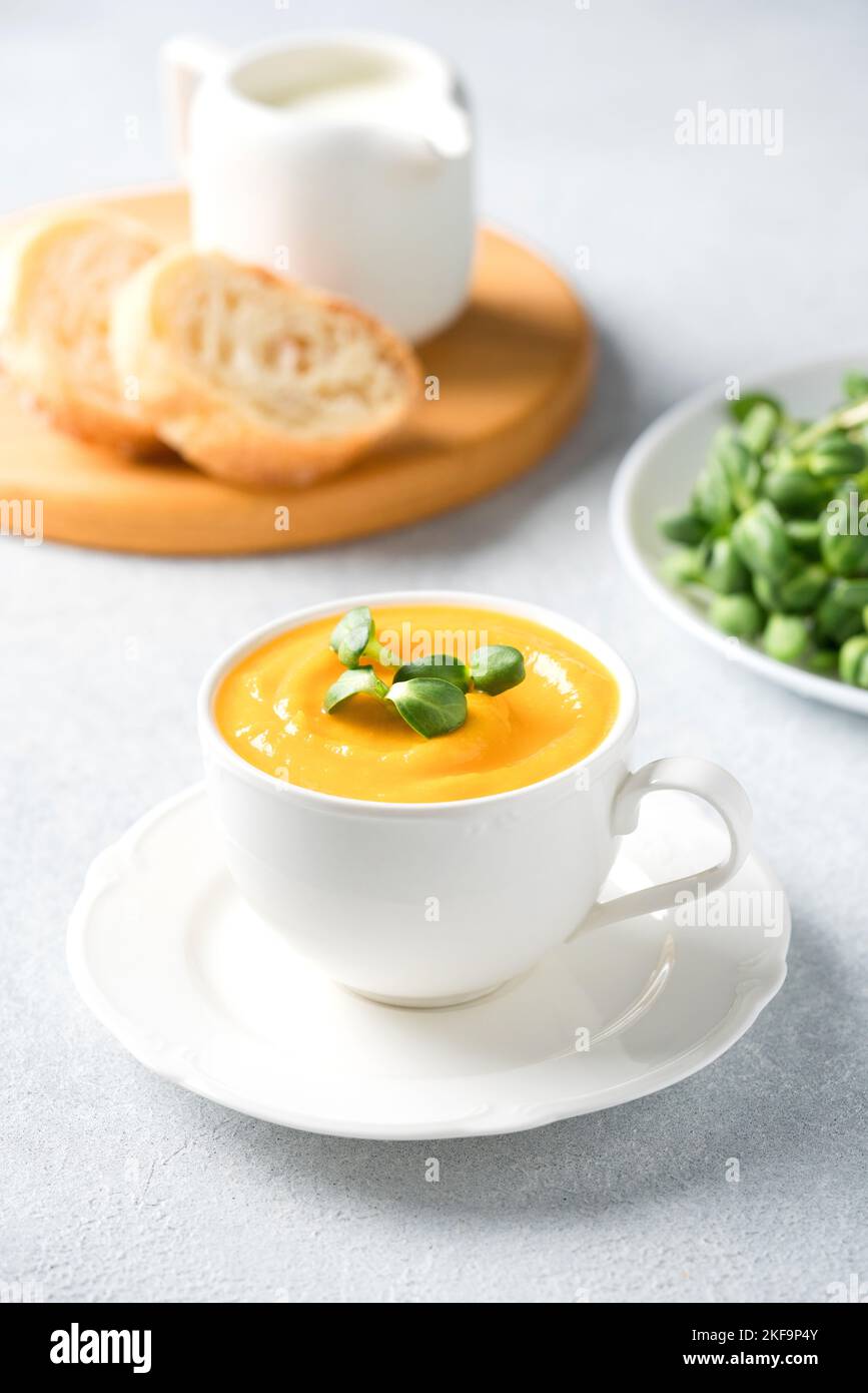 Creamy butternut squash fall soup in elegant white tea cup.Cup of ...