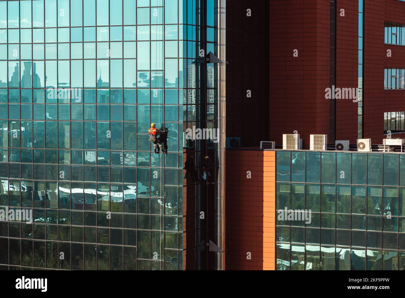 High-rise workers cleaning the windows of a skyscraper Stock Photo - Alamy
