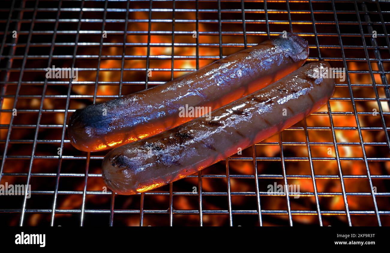 Two hot dogs roasting over a fire Stock Photo - Alamy