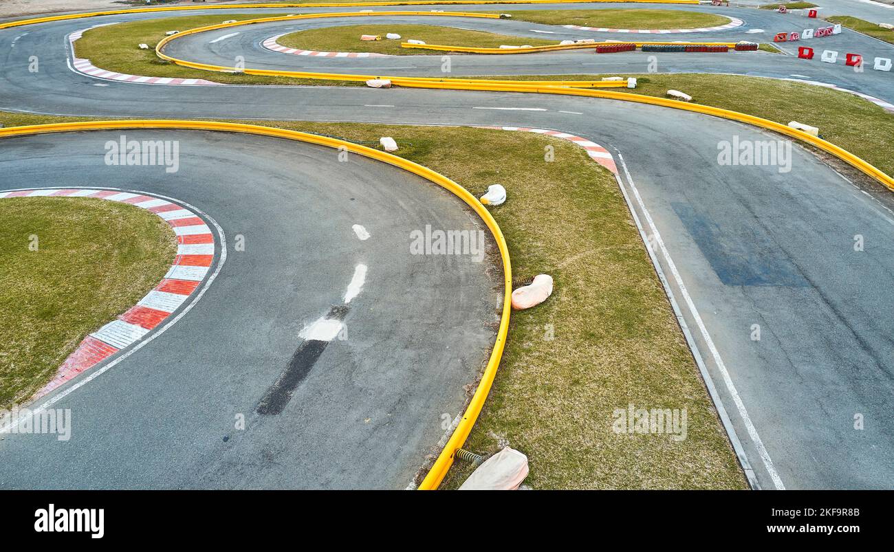 Aerial top view of the go-kart track from the drone. Kart racers drive ...