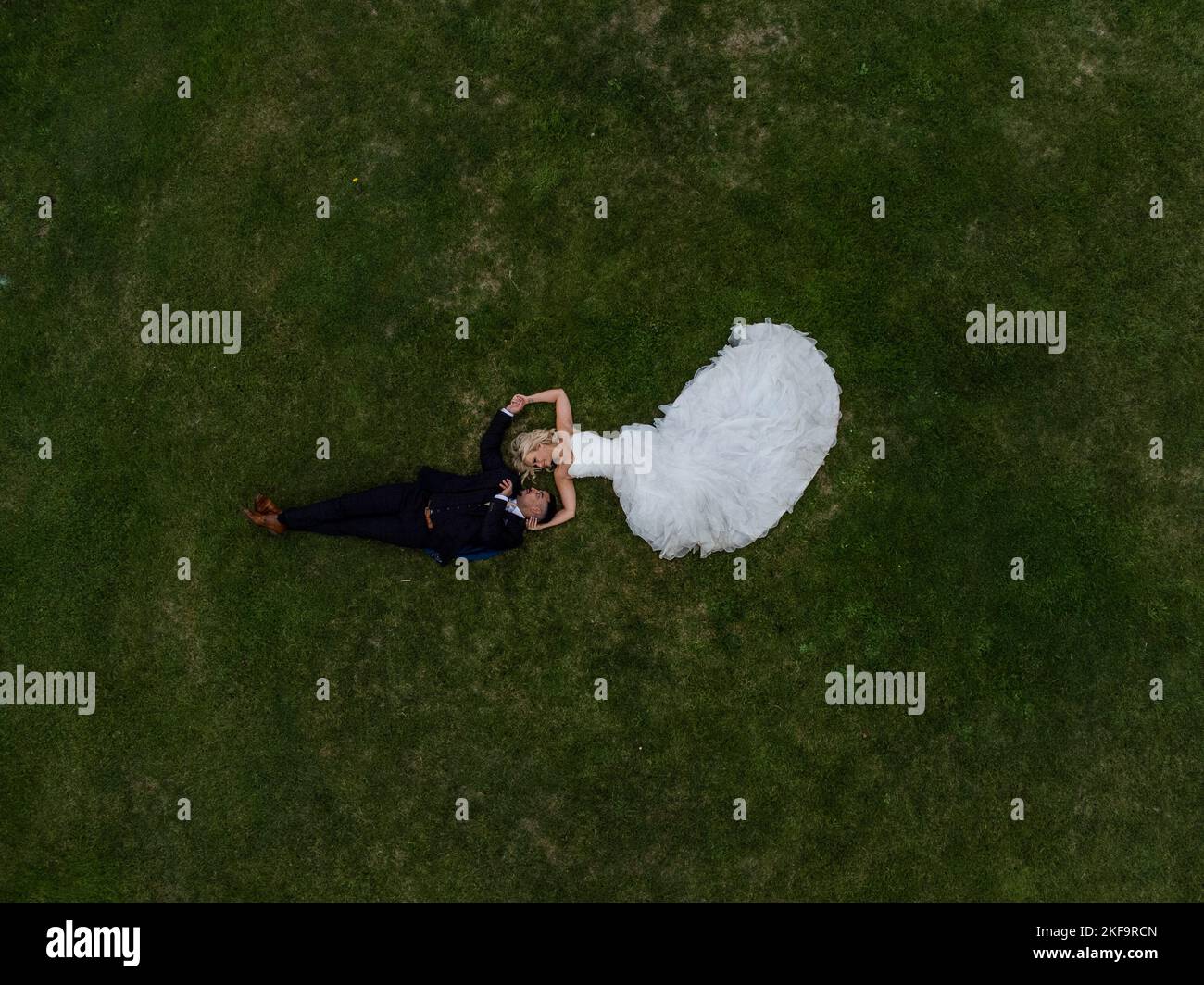 Married couple on their wedding day, laying down embracing - Drone ...