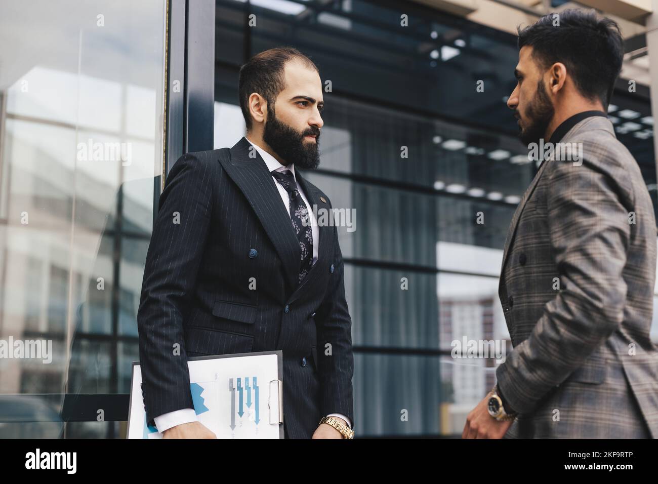 Business people outdoor meeting. Two men in suits are standing and ...