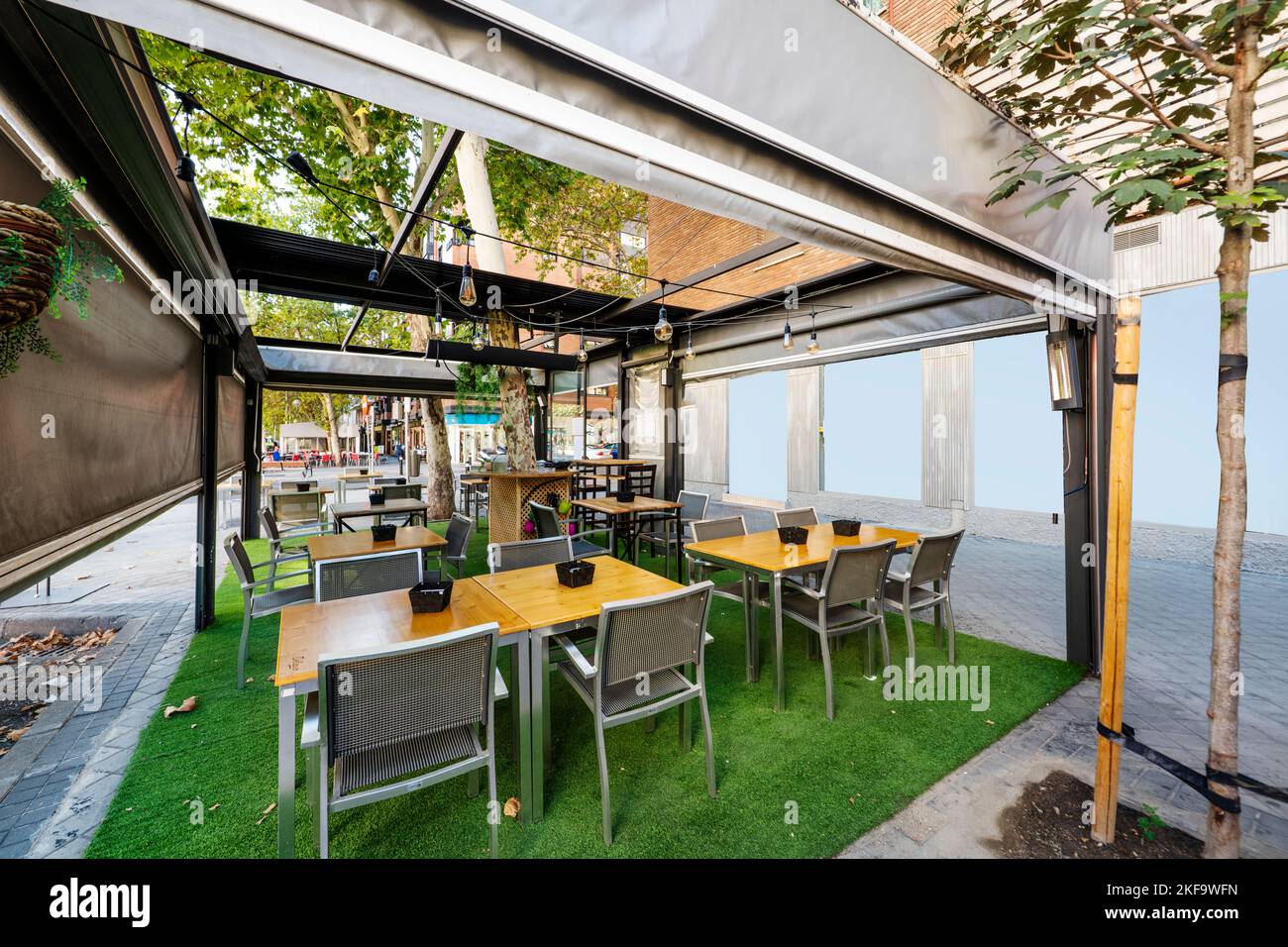 Terrace of a bar with a floor covered with artificial grass, wooden ...