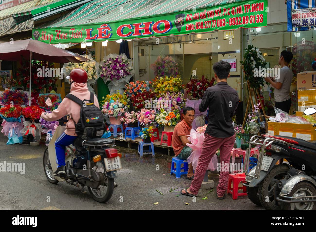 A motorcyclist passes a flower shop at the Ho Chi Minh City Flower ...