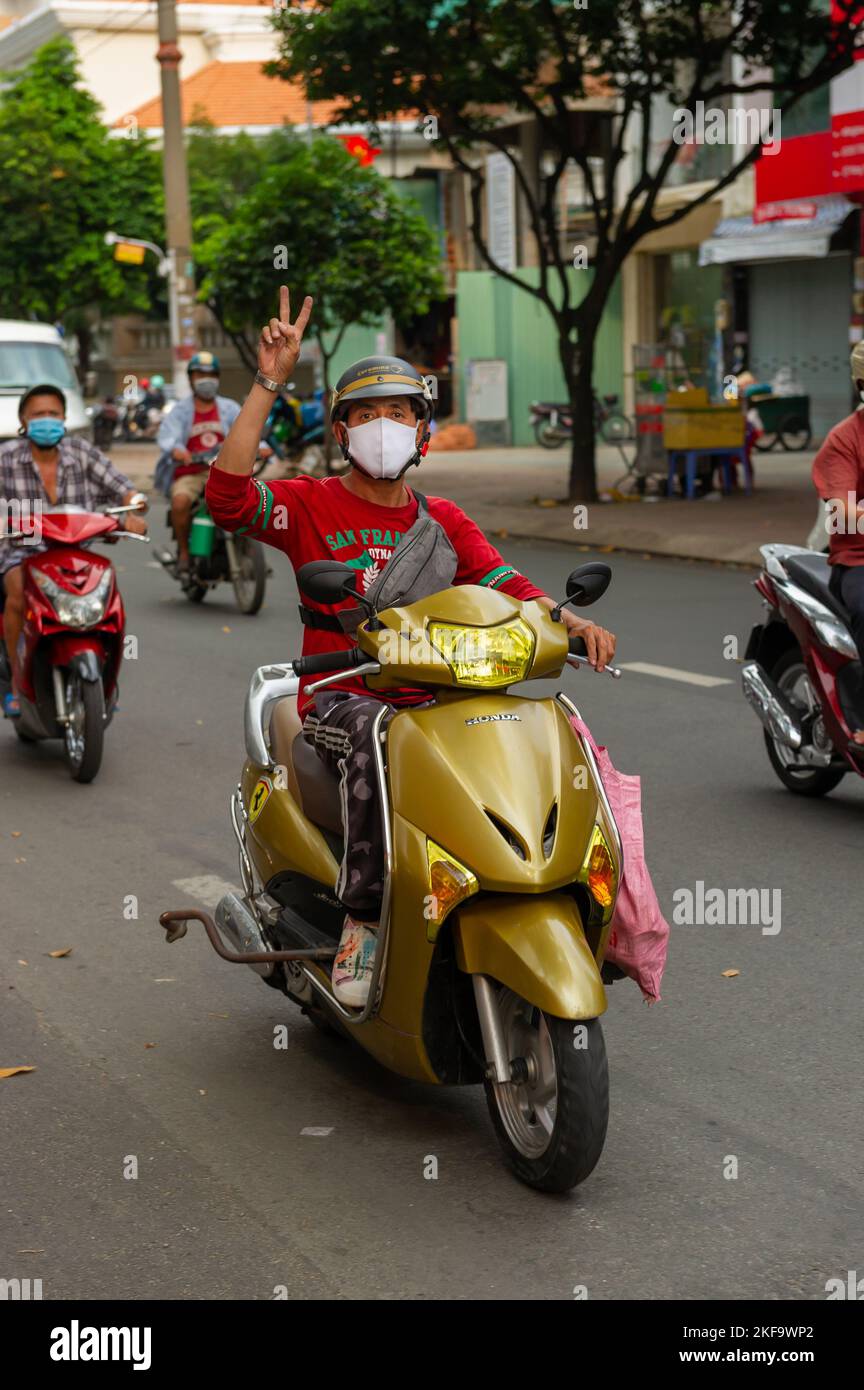 Saigon Street Life. A motorcyclist giving a V for Victory sign in Ho ...
