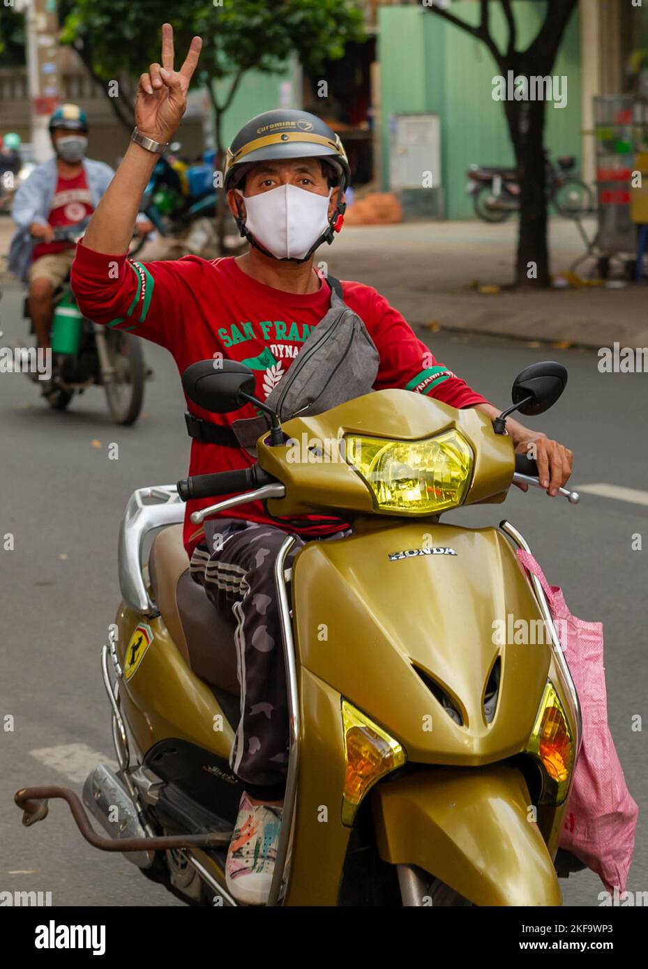 Saigon Street Life. A motorcyclist giving a V for Victory sign in Ho ...