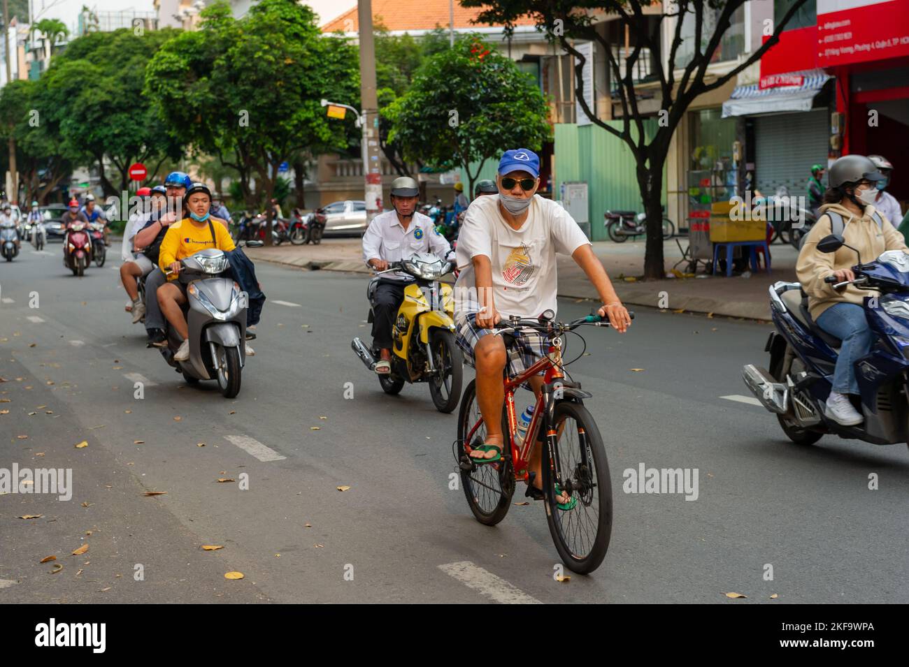 Saigon Street Life. A rush hour motorcycle swarm led by a cyclist in Ho ...