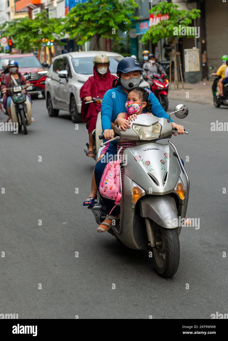 Saigon Street Life. Parents riding motorcycles with their Children in ...