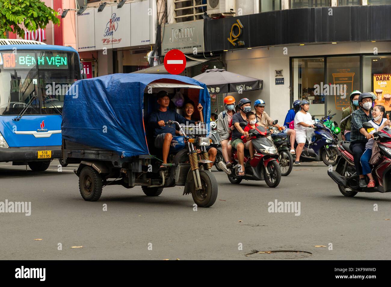 Saigon Street Life. A rush hour motorcycle swarm with a bus and Tuc Tuc ...