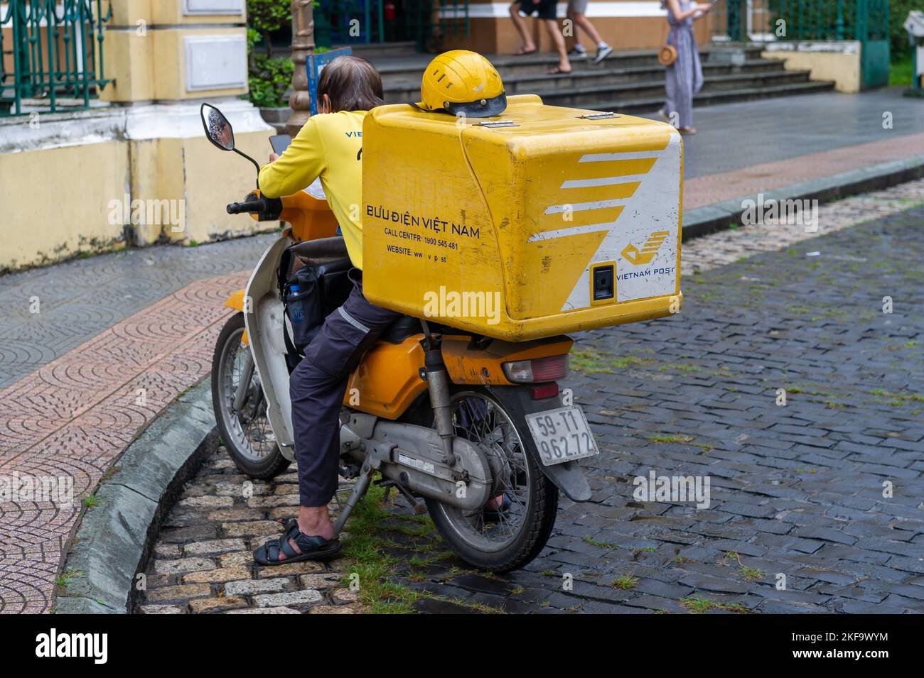 A Vietnamese Postman resting on his motorcycle outside the Ho Chi Minh ...