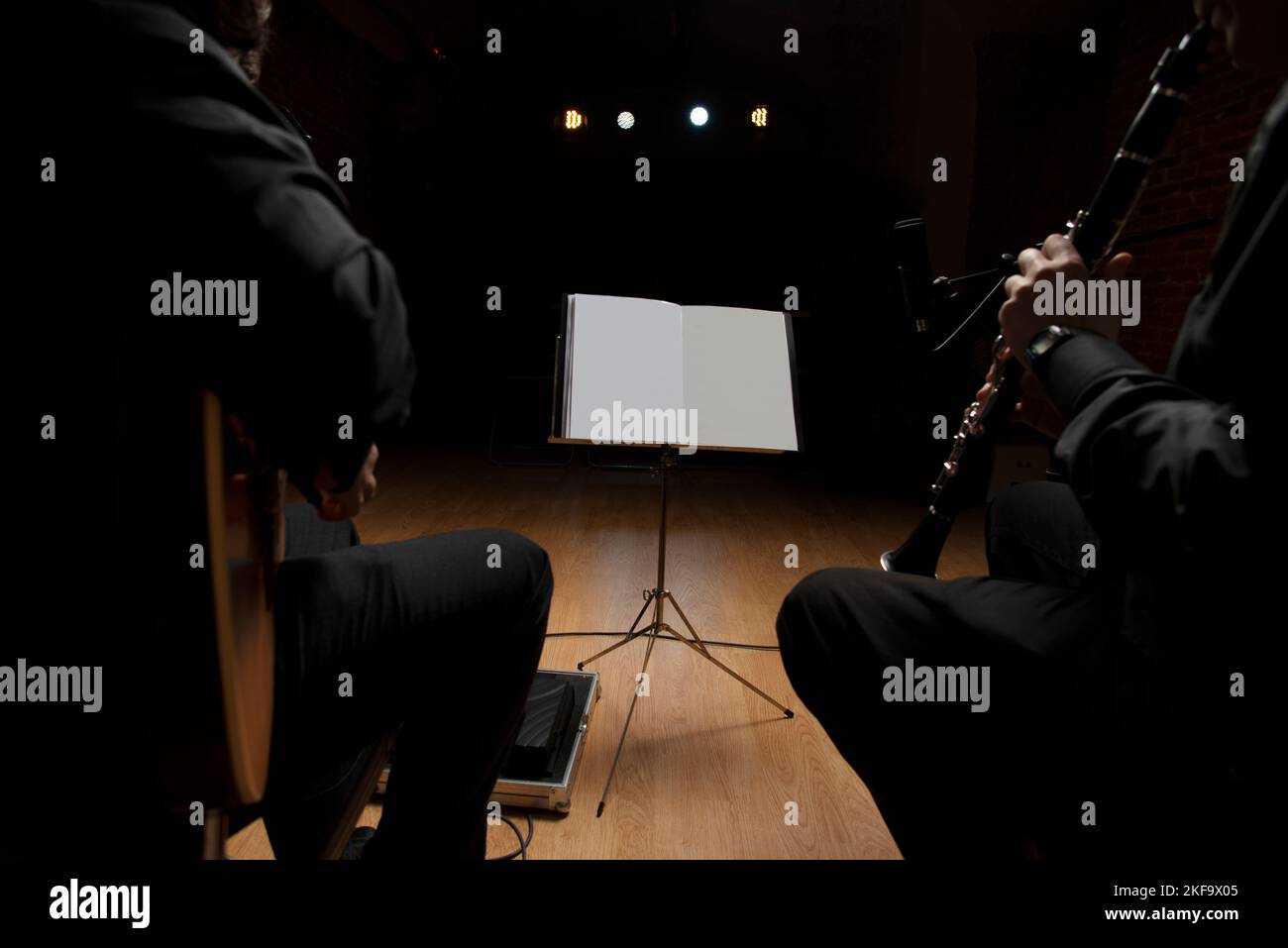 Two musicians sitting in front of a sheet of music ready to play the ...
