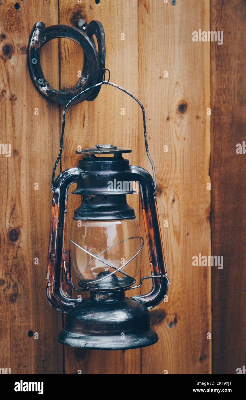 Old fashioned kerosene storm lamp hanging on wooden door Stock Photo ...
