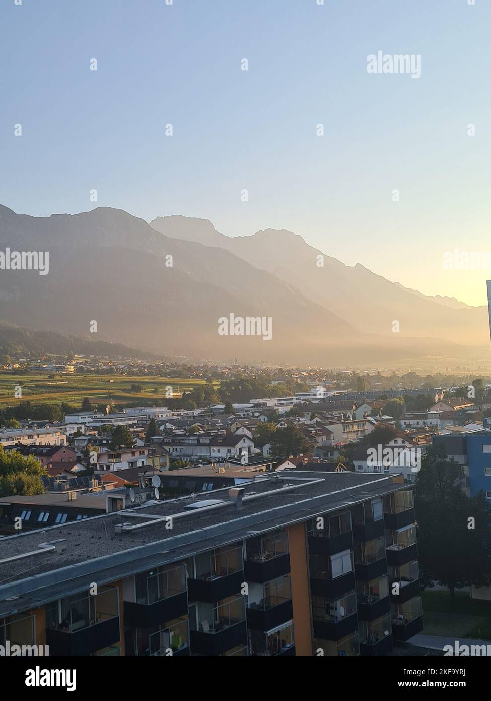 A vertical aerial view of buildings in a city under bright sunlight ...