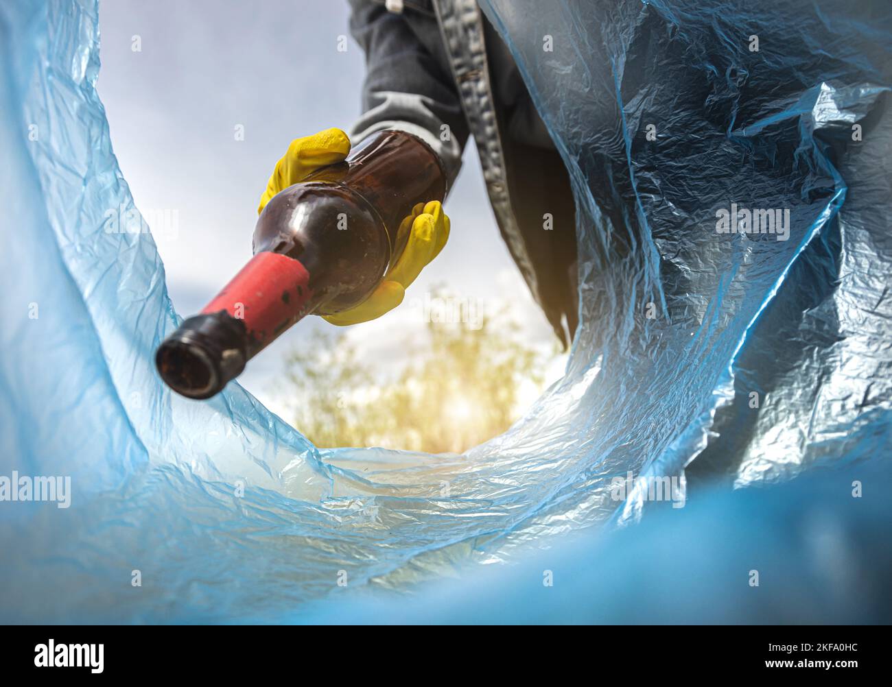 Close-up of a hand throwing garbage into a plastic bag. View from ...