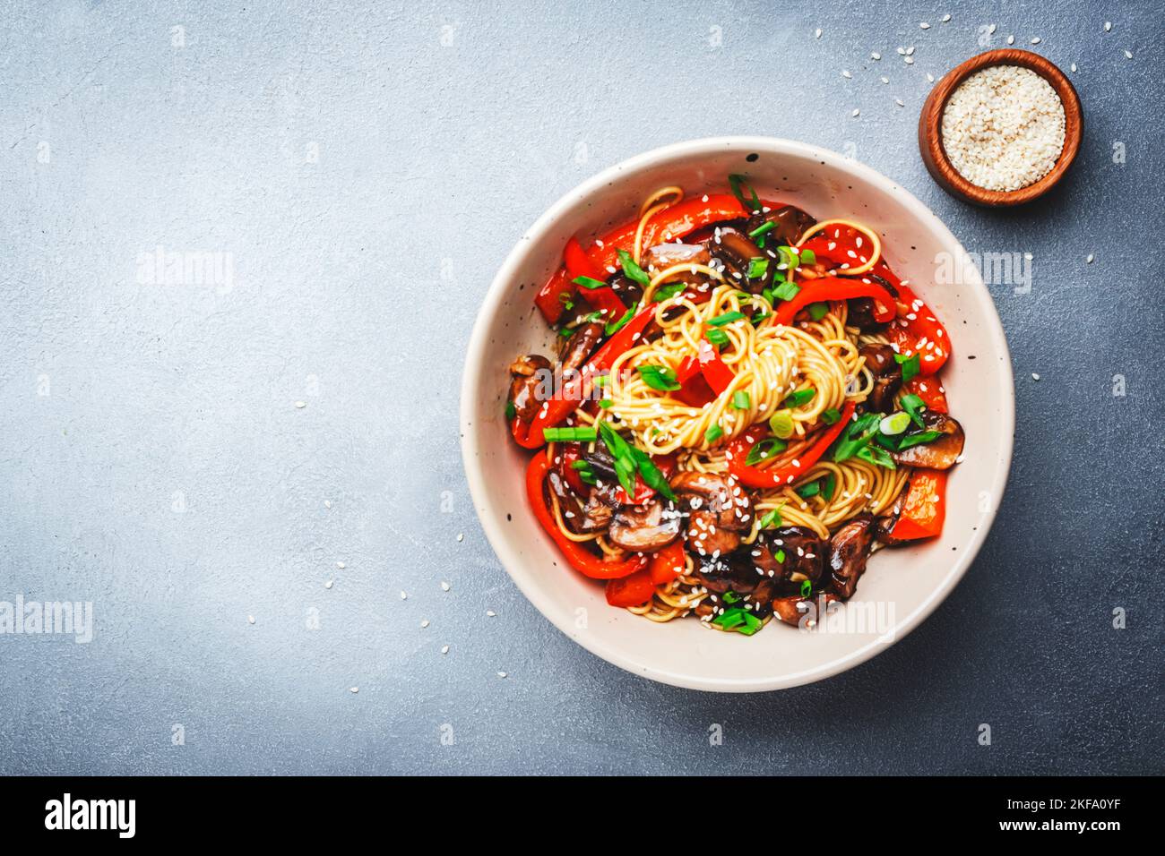 Vegetarian stir fry noodles with vegetables, paprika, mushrooms, chives ...
