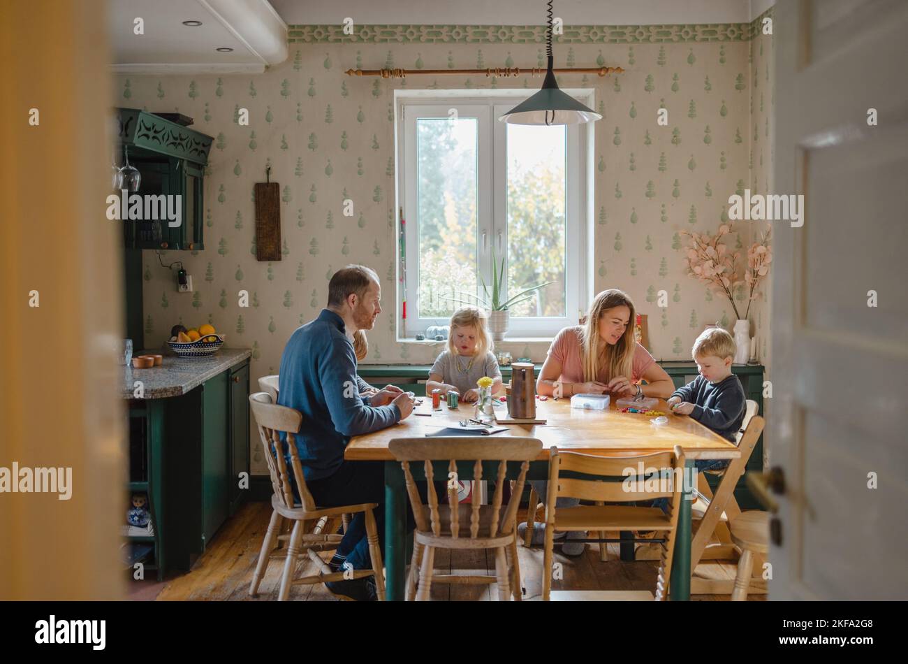 Happy young family at dining table at home together Stock Photo - Alamy