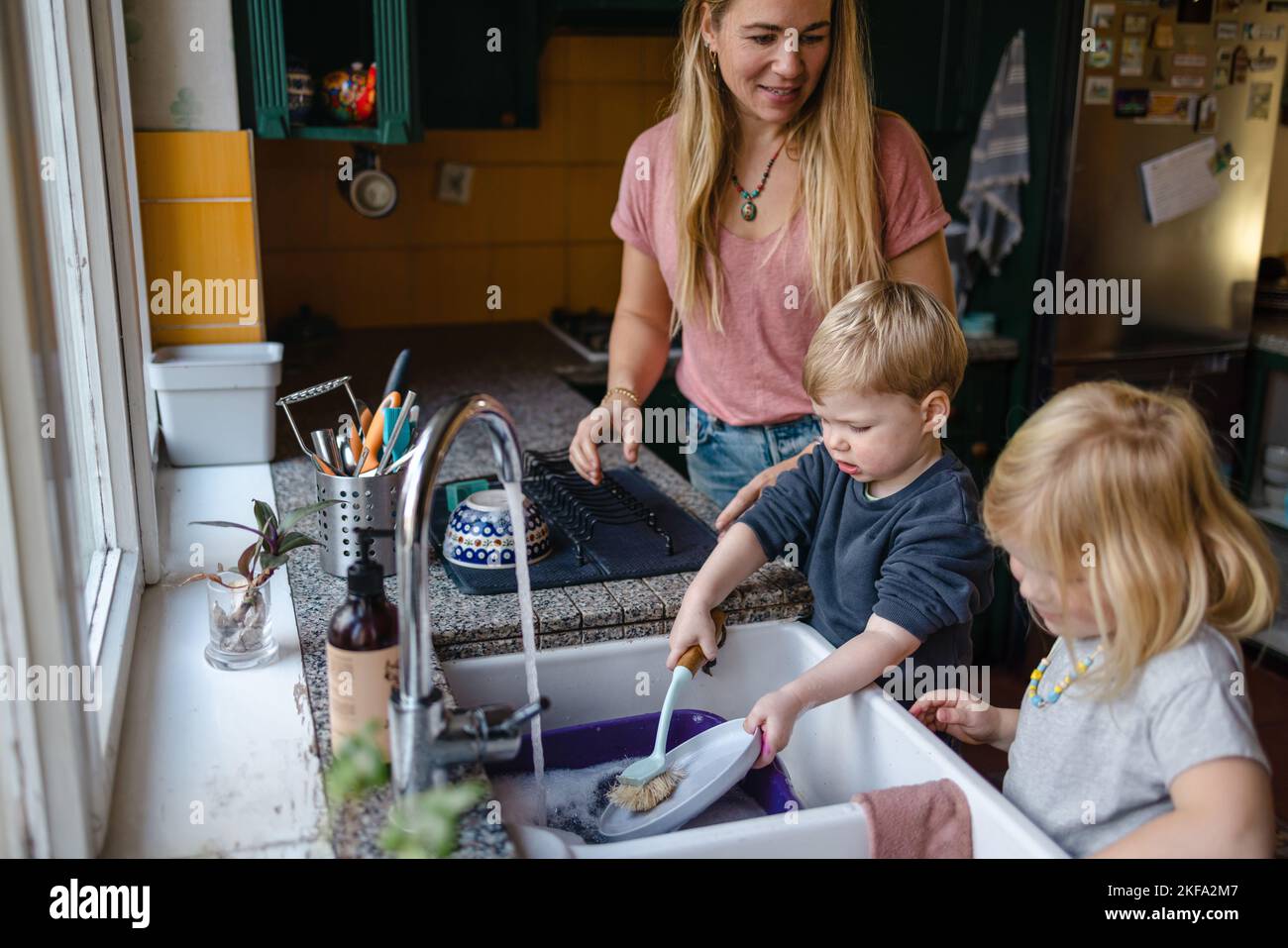 Children helping mother washing dishes in the kitchen Stock Photo - Alamy