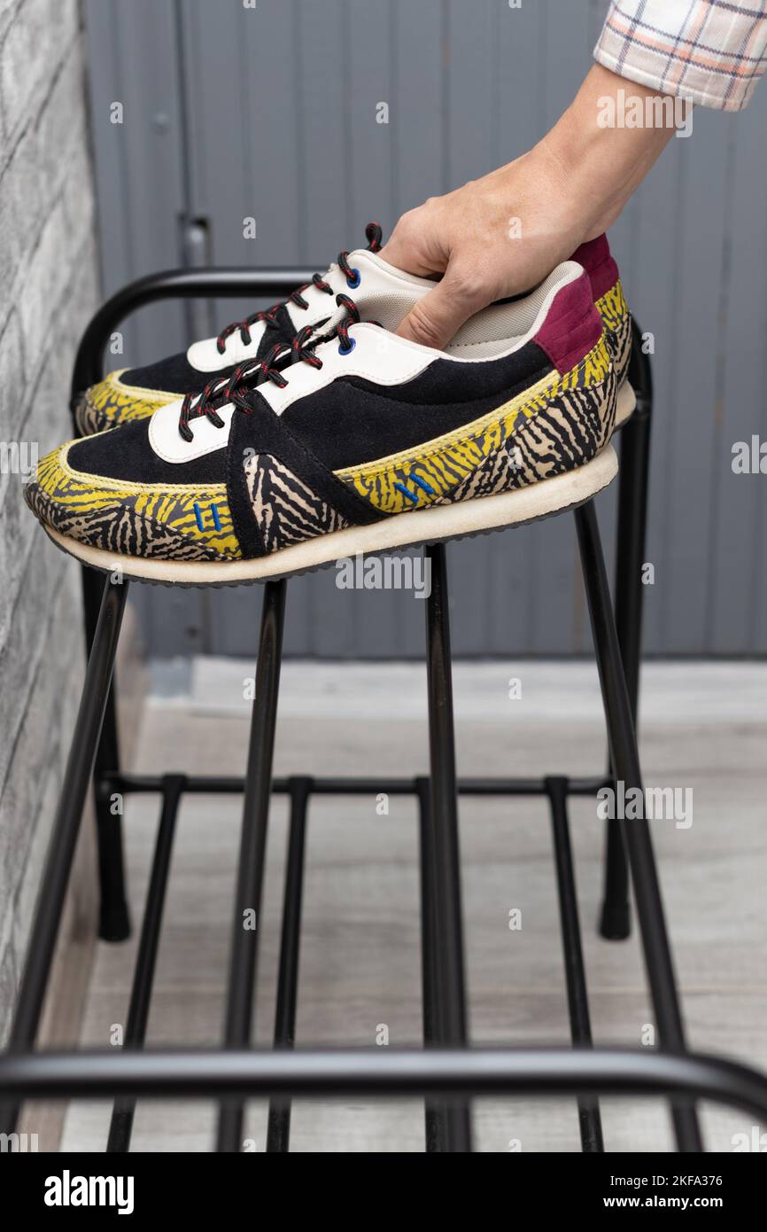 girl puts on sneakers after returning from a walk. man putting on shoes ...