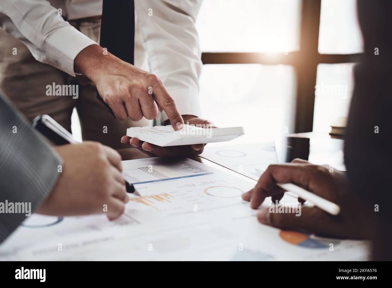 businesspeople using calculator to calculate with partners adjusting ...