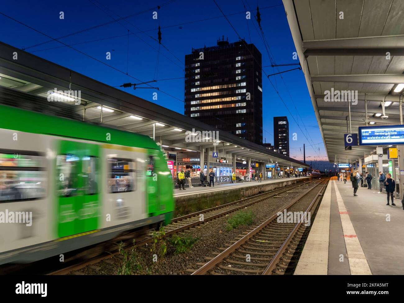 Railway station, suburban train on platform, skyline of Essen city ...