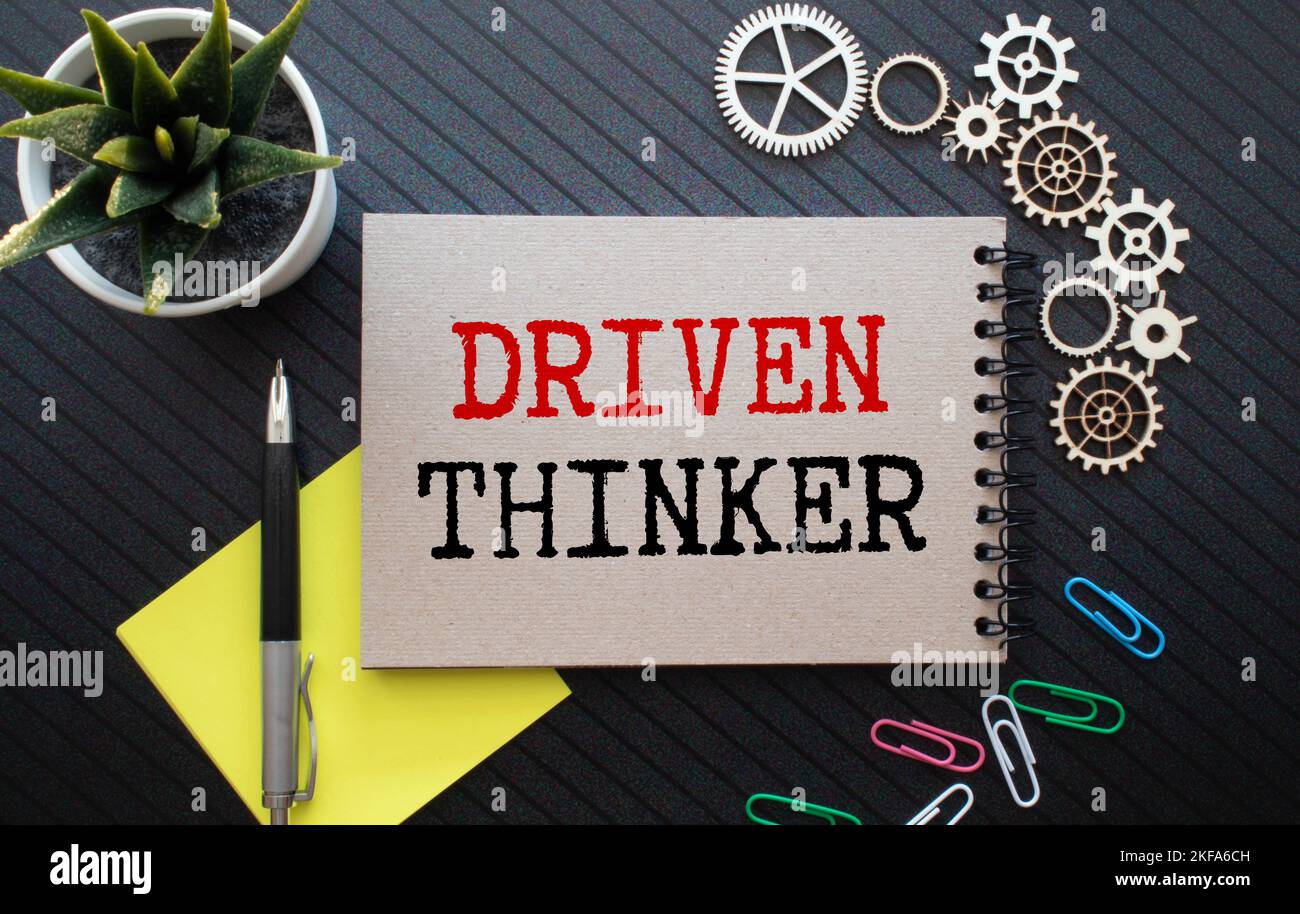 Closeup on businessman holding a card with text DRIVEN THINKER ...
