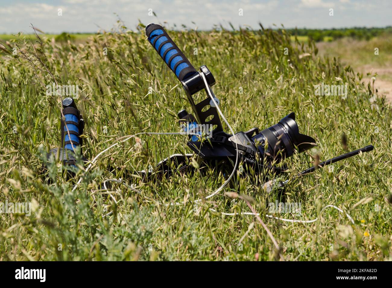 Close up video camera laying in grass concept photo. Meadow. Side view ...