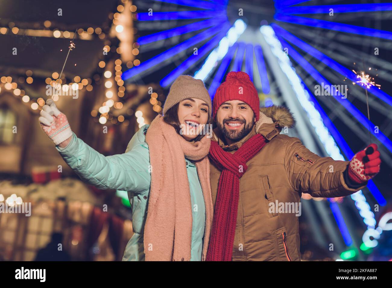 Photo of two positive satisfied partners hands hold bengal light stick ...