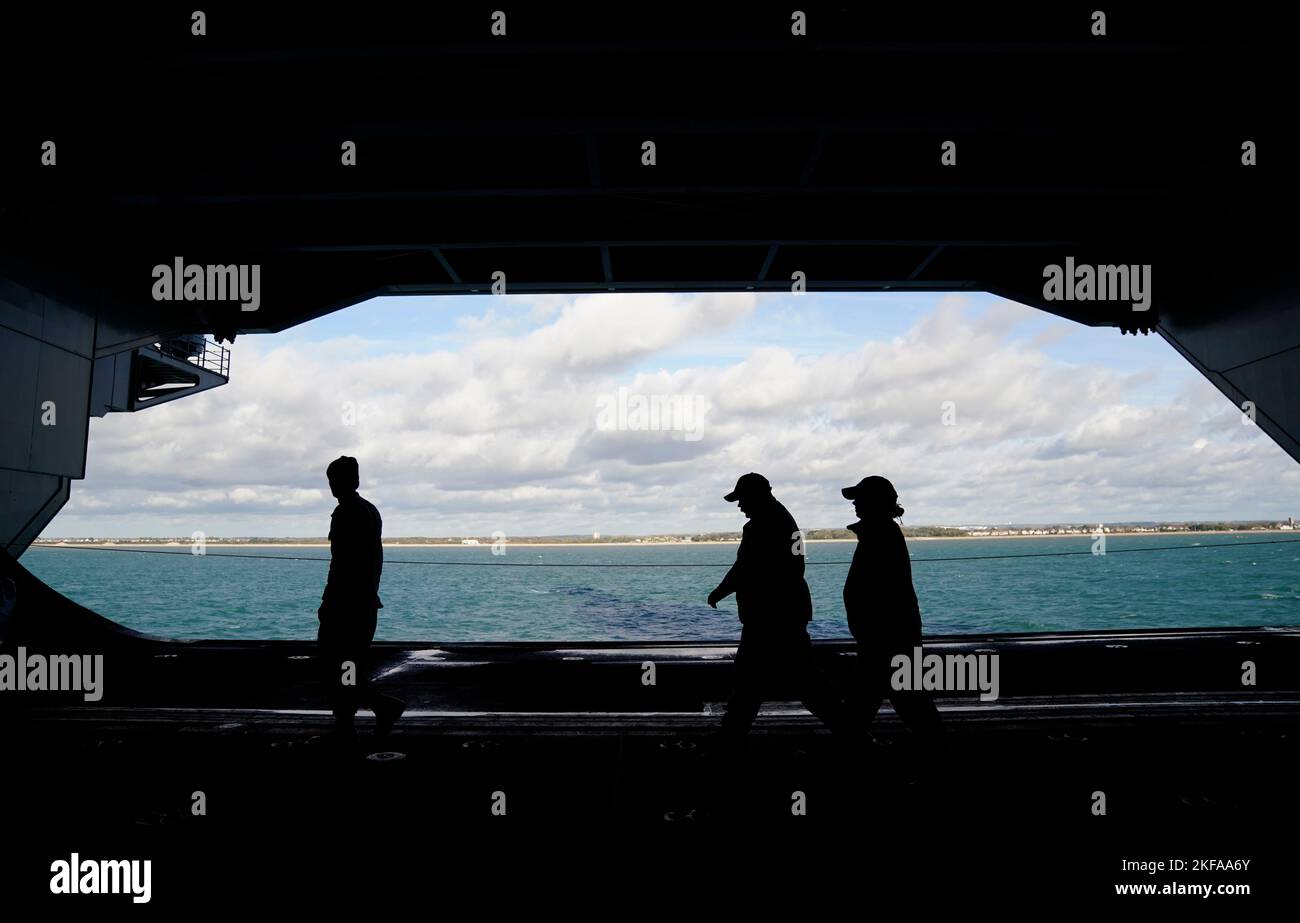 Crew members are silhouetted as they walk in the hanger on board the ...
