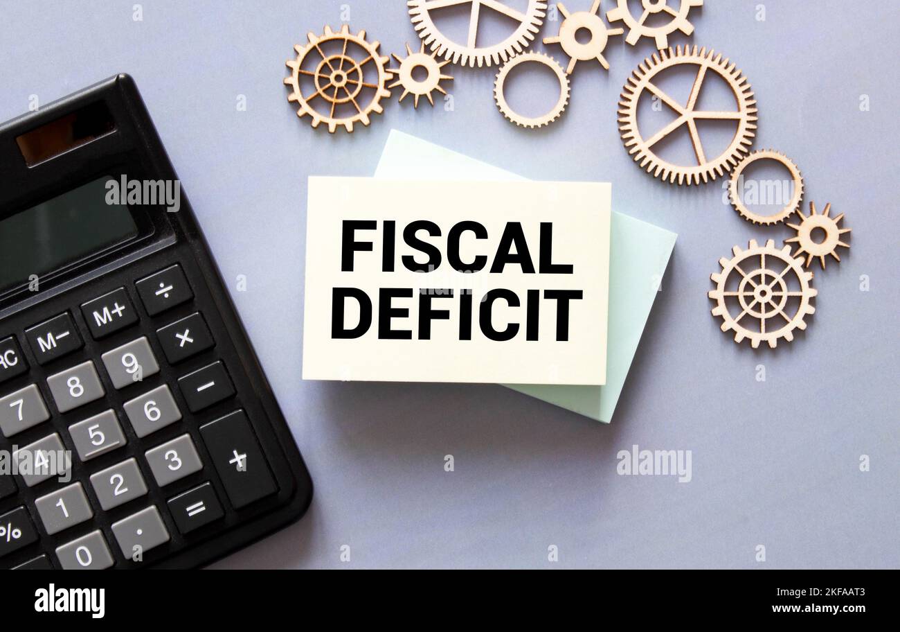The words FISCAL DEFICIT is written on white paper card near a wooden ...