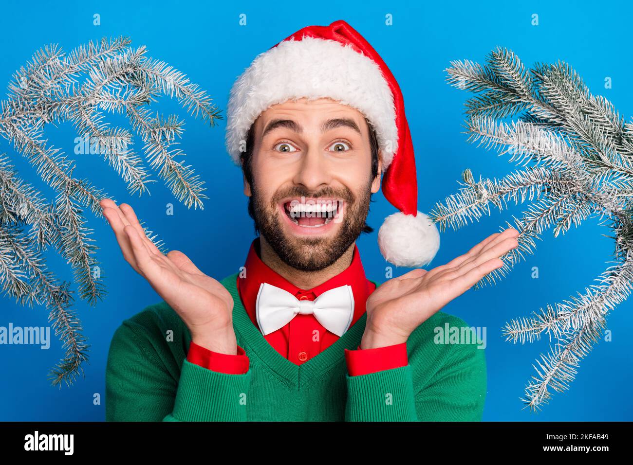 Close up photo of overjoyed positive man between spruce pine branches ...