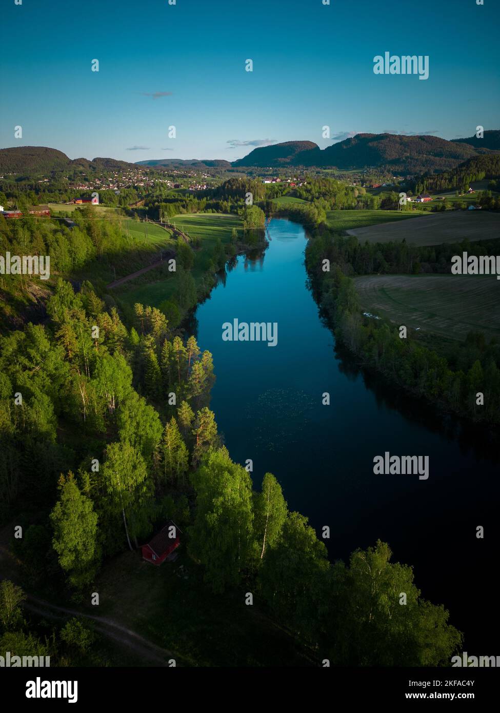 A drone view of a calm river and green landscapes in spring Stock Photo ...