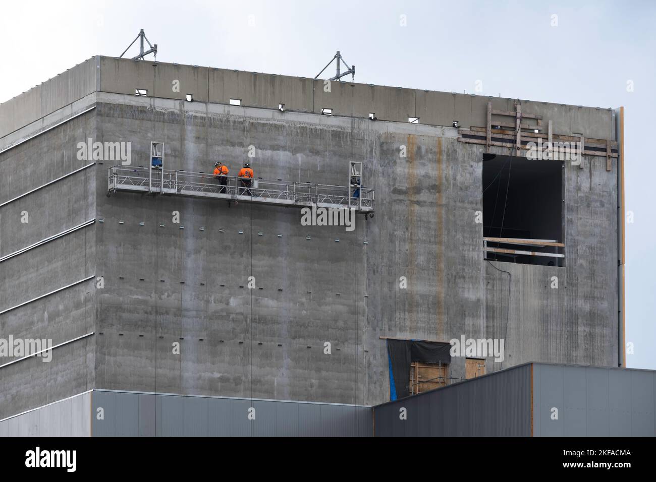 Two construction workers wearing safety harness and seat belts working ...
