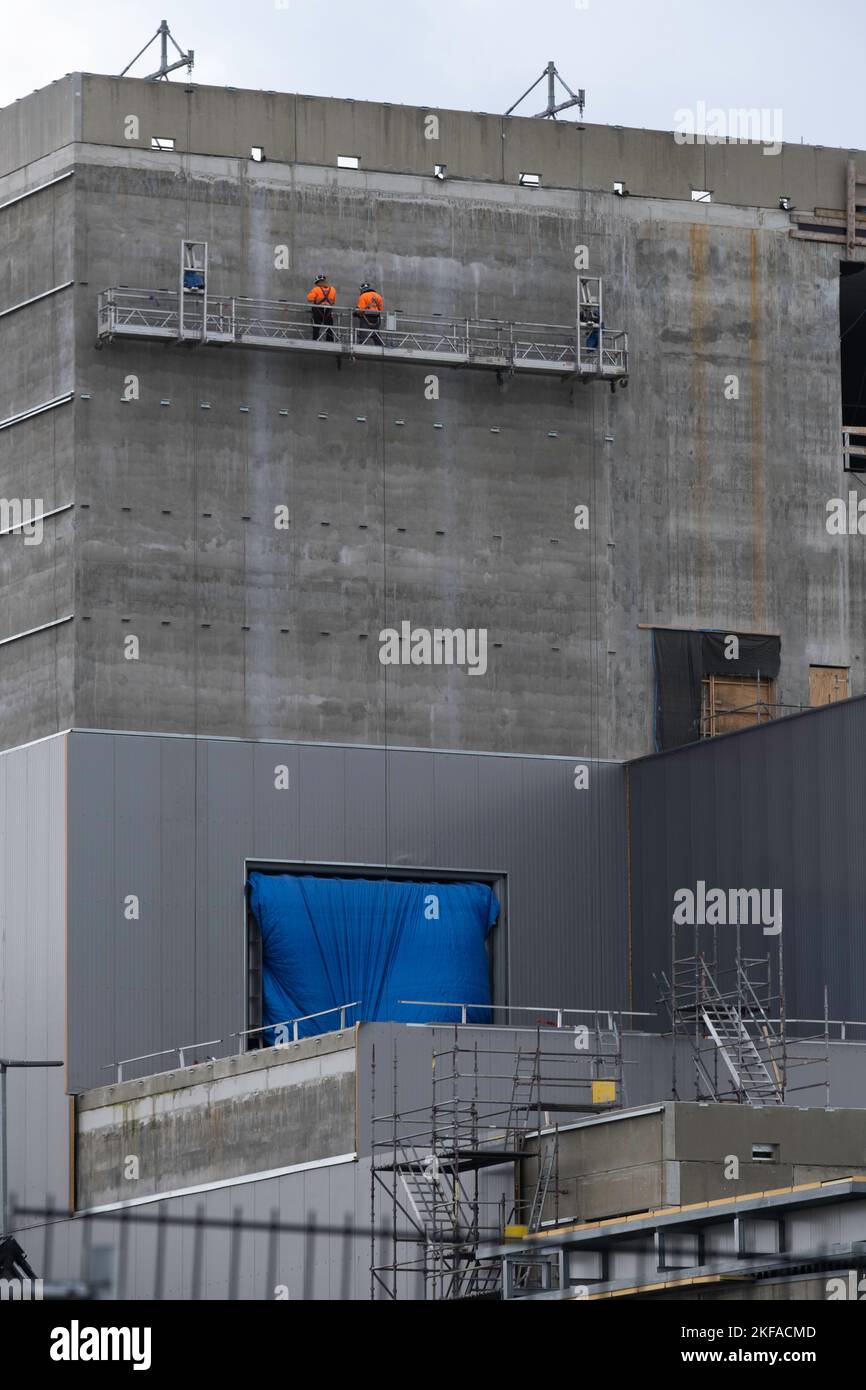 Two construction workers wearing safety harness and seat belts working ...