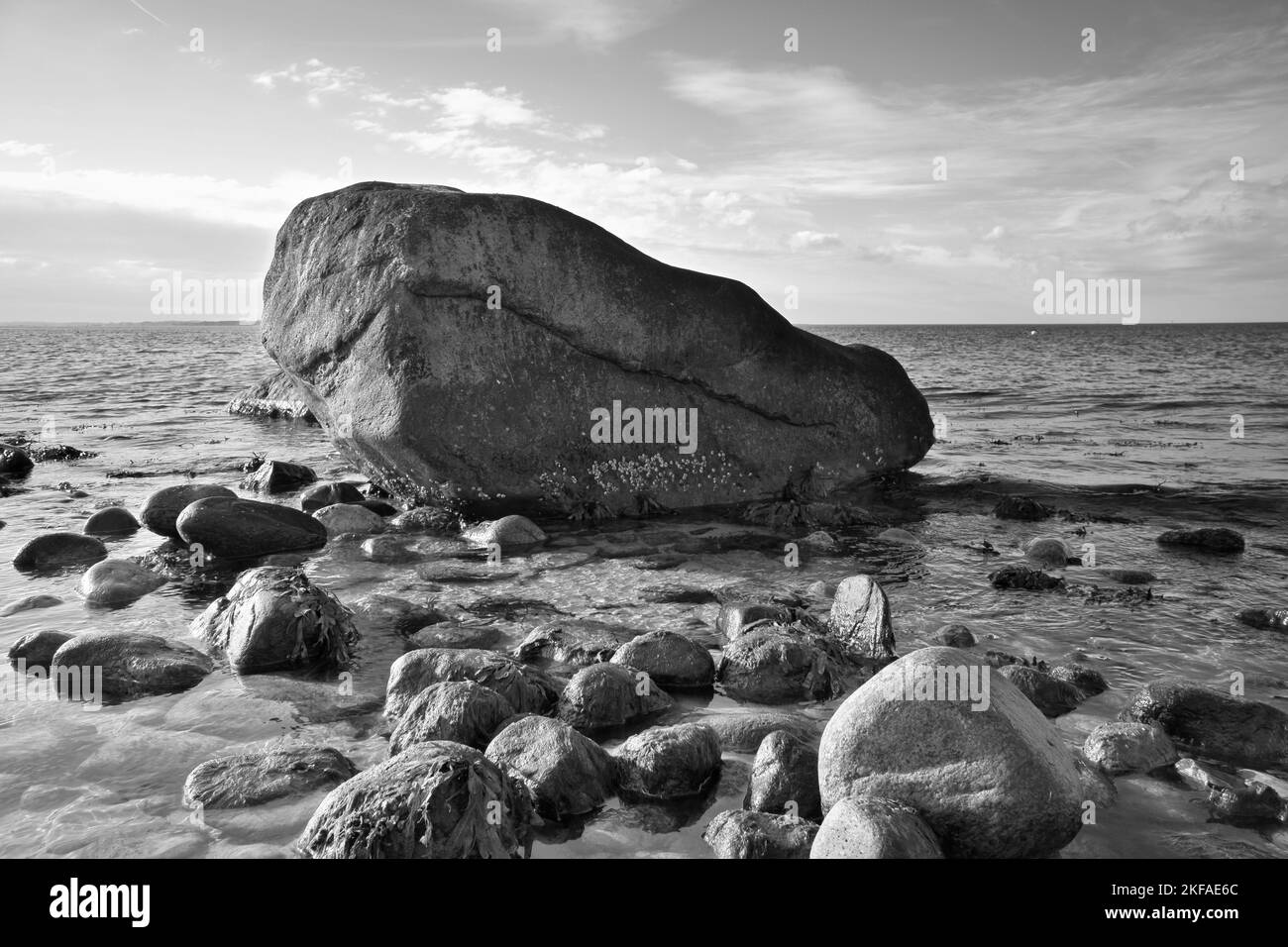 Large stone in black and white taken in the water on the beach in the ...