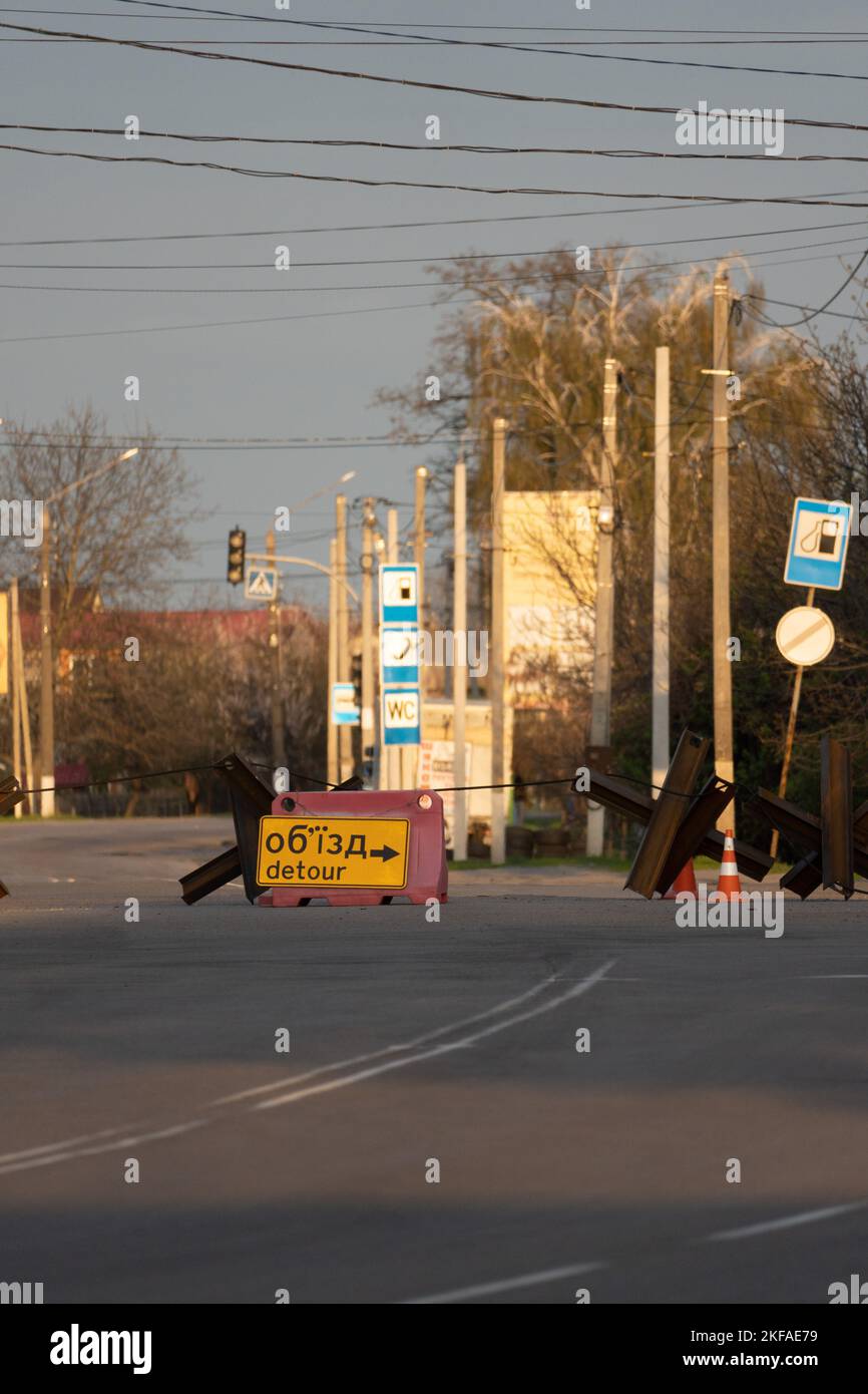 A vertical shot of asphalt street blocked by metal structures in a city ...