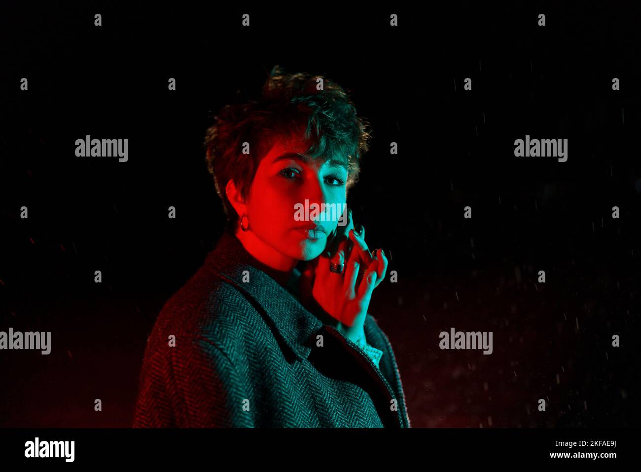 Frozen Caucasian woman as with coat draped over shoulders posing ...