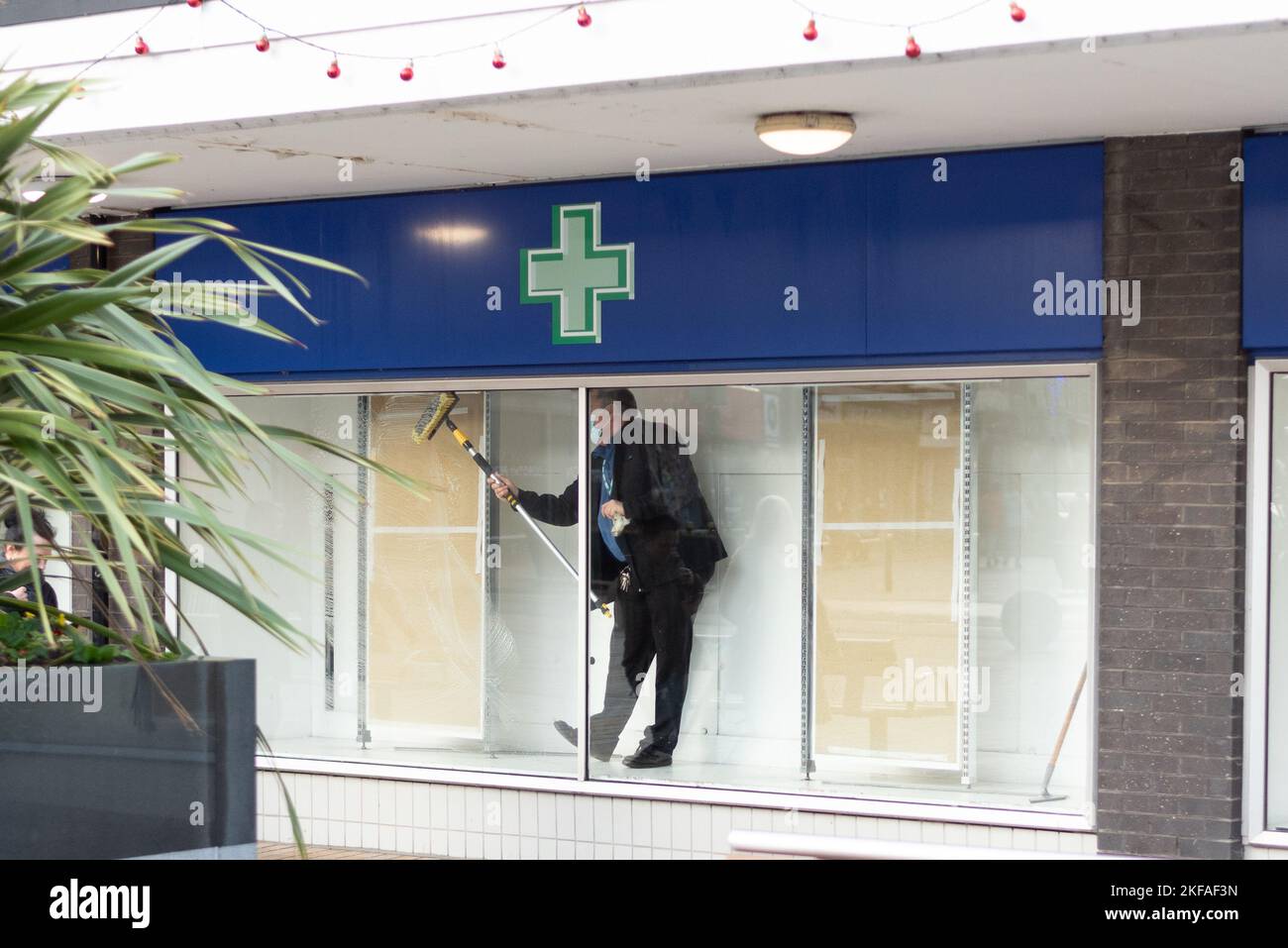 Man cleaning windows in Boots the chemist. Men working. Window cleaner ...
