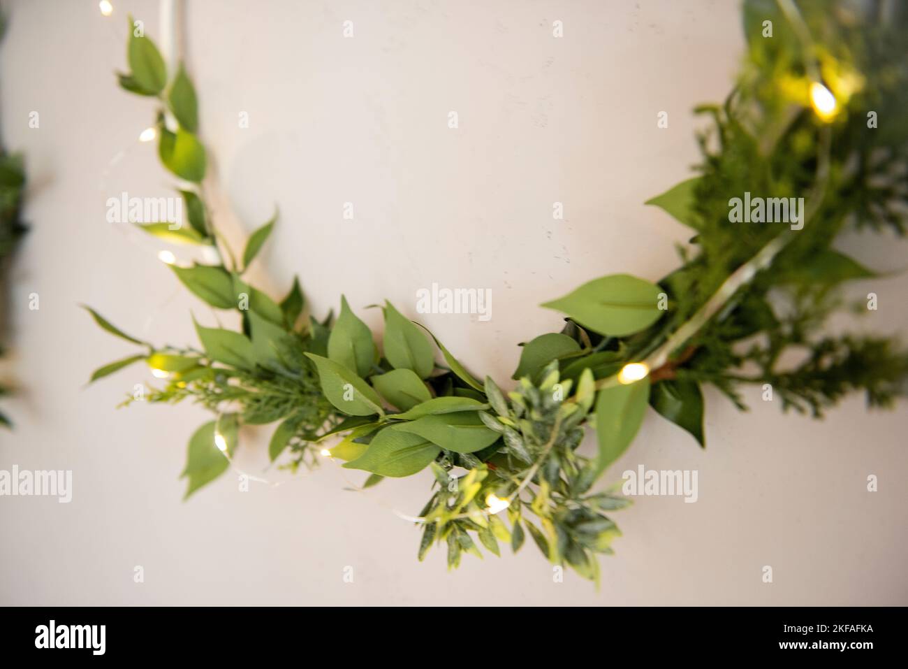 On gray concrete wall, there are three laconic, elegant, green wreaths ...