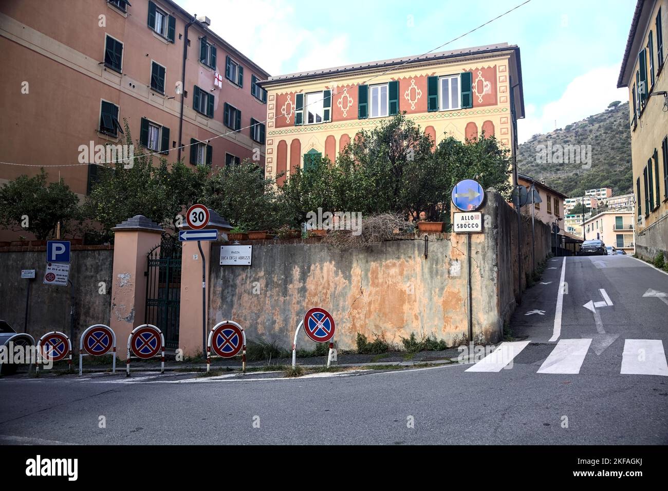 Narrow up hill street next to a wall on a cloudy day Stock Photo - Alamy