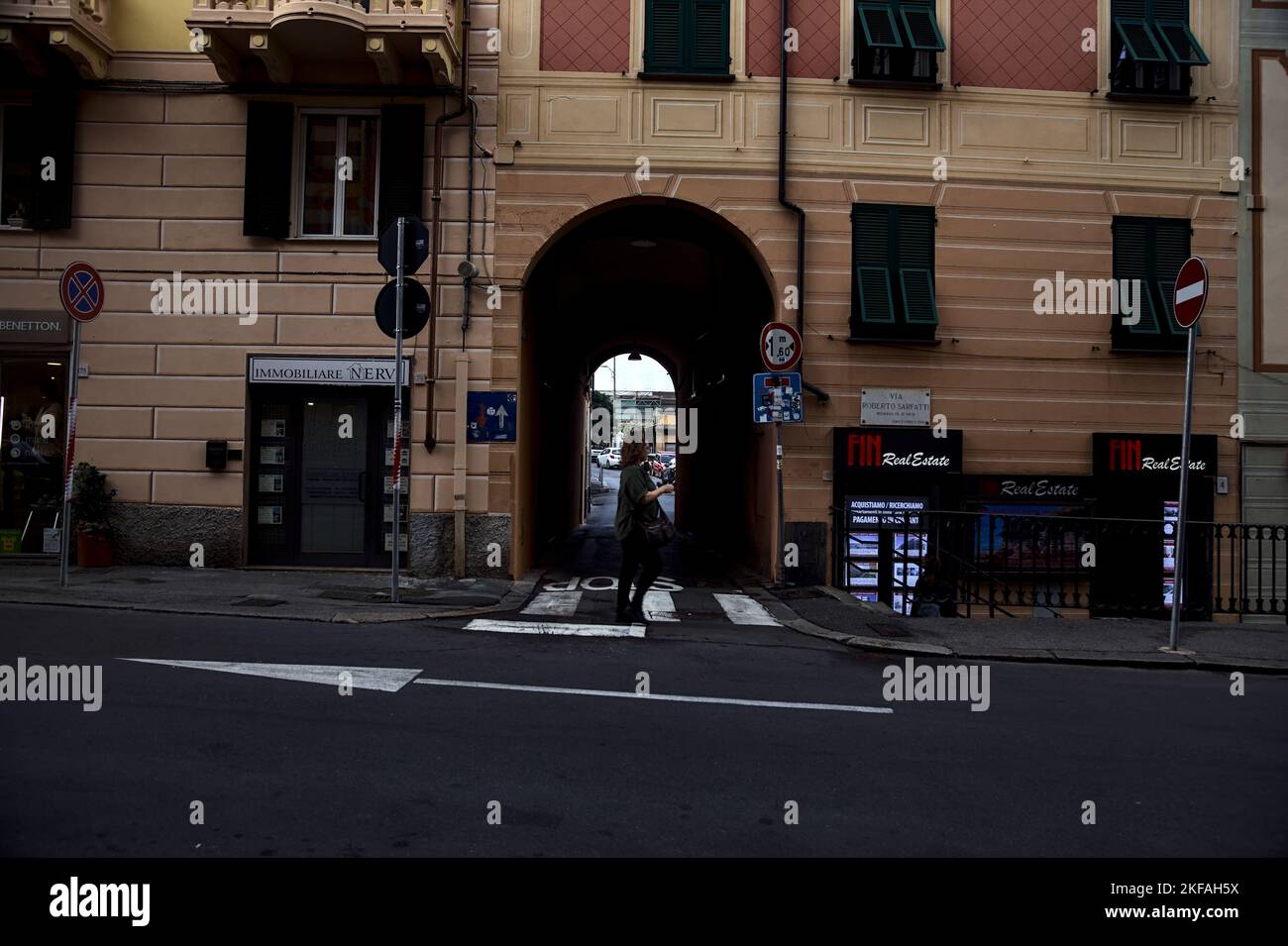 Alley in opening of a building by the edge of a street Stock Photo - Alamy