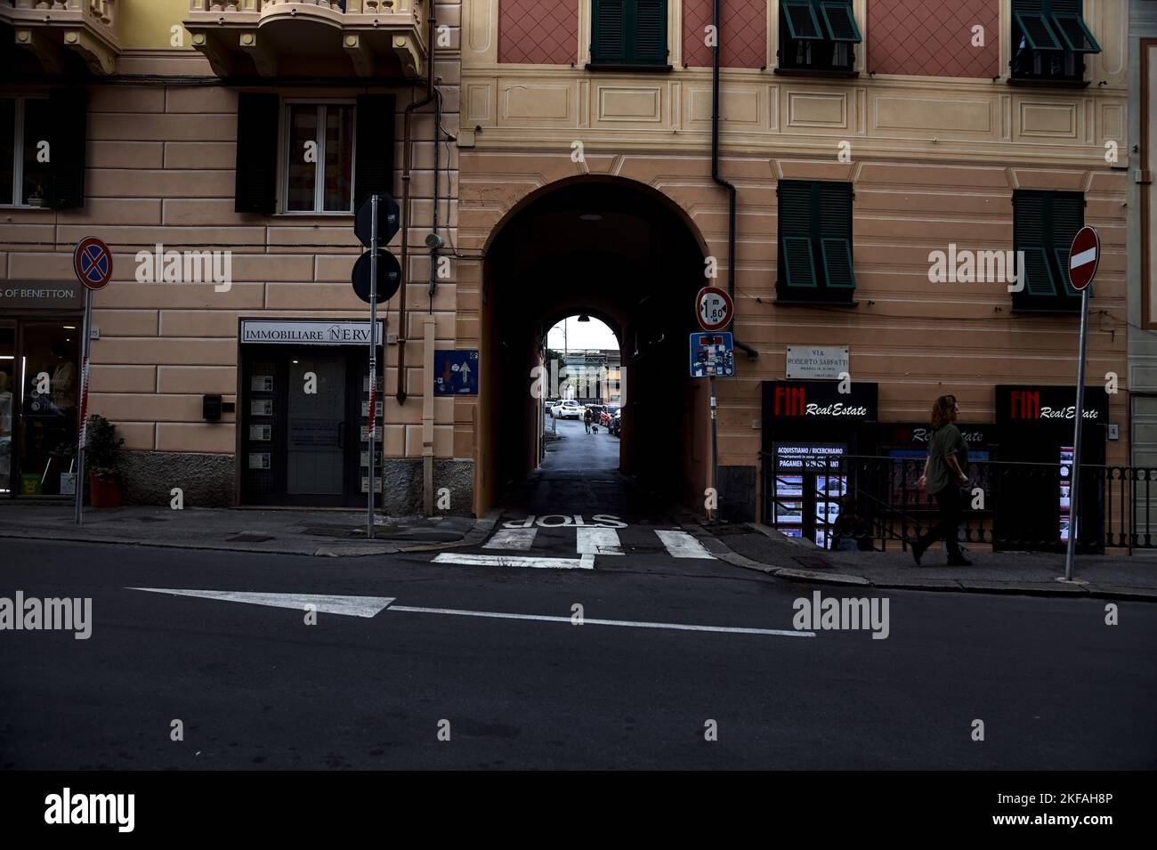 Alley in opening of a building by the edge of a street Stock Photo - Alamy