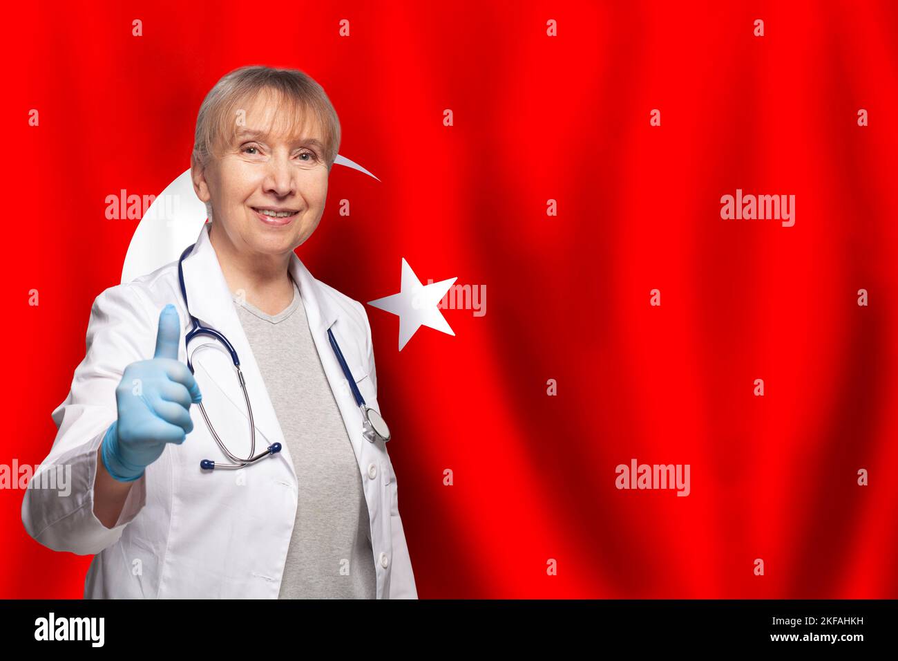 Turkish smiling mature doctor woman holding stethoscope on flag of ...