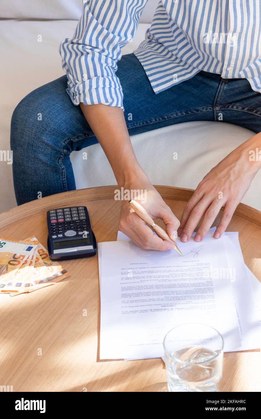 Vertical view of unrecognizable man signing contract document on a ...