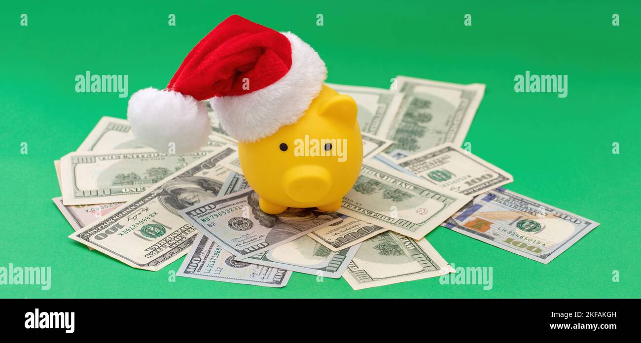 Christmas holiday bonus and expenses. Piggy bank with Santa hat on US ...